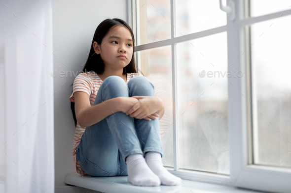 Bored asian girl sitting on windowsill alone, copy space Stock Photo by ...