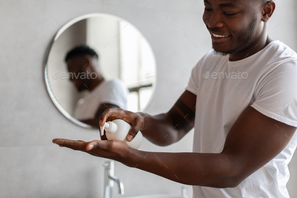 Black Guy Using Liquid Soap From Bottle In Modern Bathroom Stock Photo ...