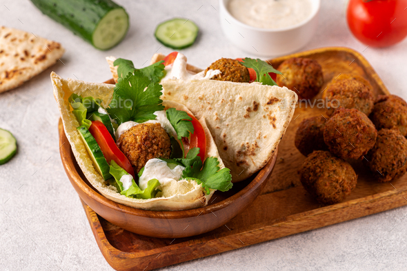 Falafel and fresh vegetables in pita bread Stock Photo by tatiana_bralnina