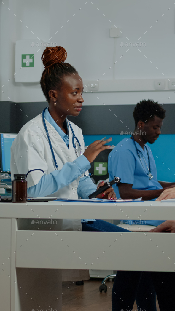 African american doctor holding medical otoscope on old man Stock Photo ...
