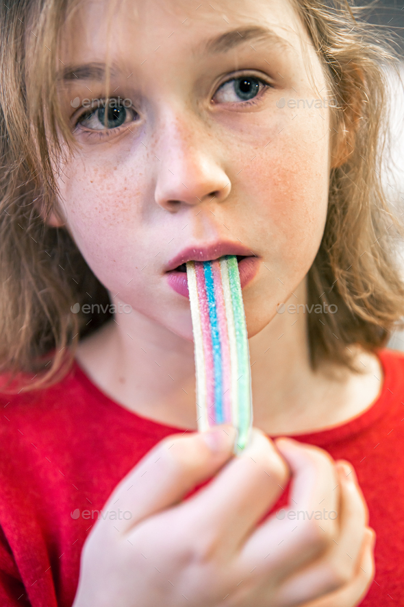 Close up, little girl eating gummy candy. Stock Photo by puhimec ...