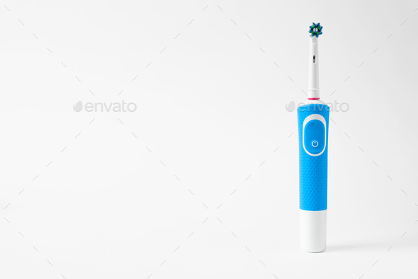 Blue modern electric toothbrush standing on a white background, copy ...