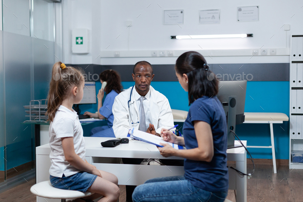Girl patient mother writing medical accord on document Stock Photo by ...