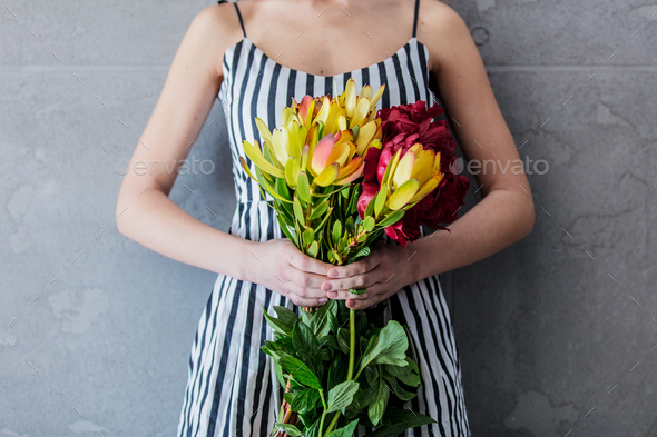 Female holding bouquet with sunset safari flowers Stock Photo by Masson ...