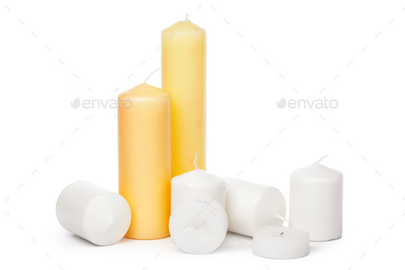 different sized candles on a white background Stock Photo by FabrikaPhoto