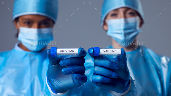 Two Female Lab Research Workers In PPE Holding Test Tubes Labelled ...