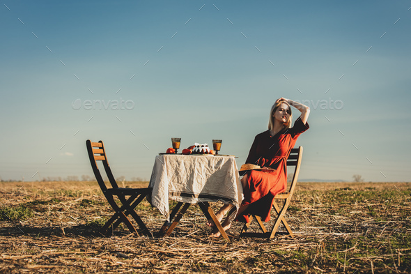 Beautiful girl sits at a table during dinner in a field Stock Photo by ...
