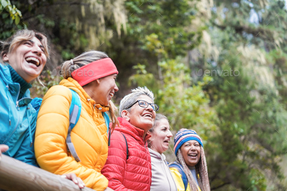 Multiracial women having fun exploring nature on trekking day in ...