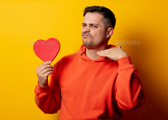 discontent man with heart shape box on yellow background Stock Photo by ...