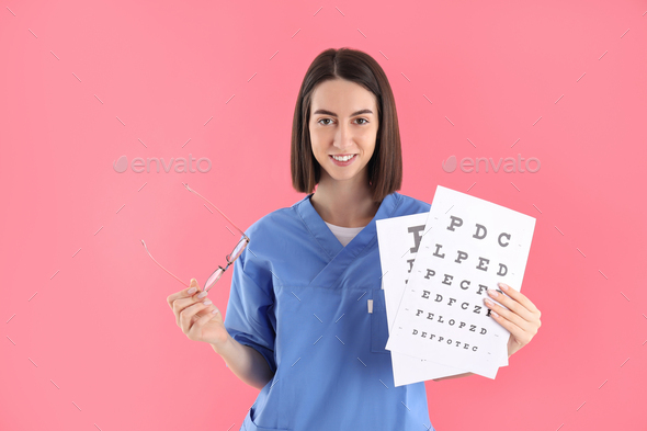 Female nurse with glasses and vision test on pink background Stock ...
