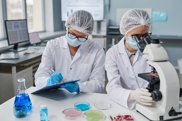 People examining samples in the lab Stock Photo by seventyfourimages