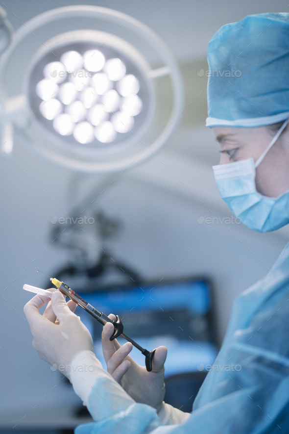 Dentist preparing a surgical syringe Stock Photo by karrastock | PhotoDune