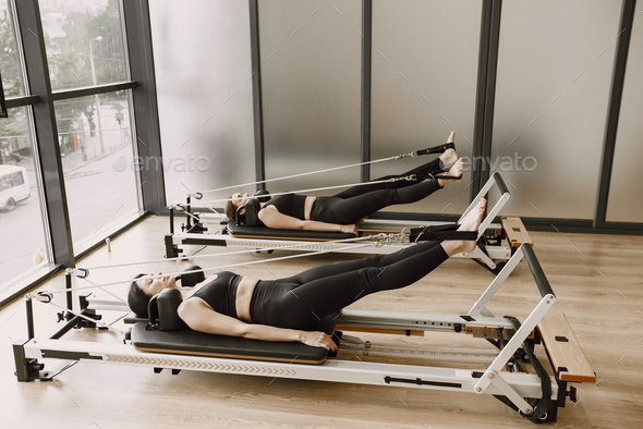 Two girls in a bright gym doing functional training with equipment ...