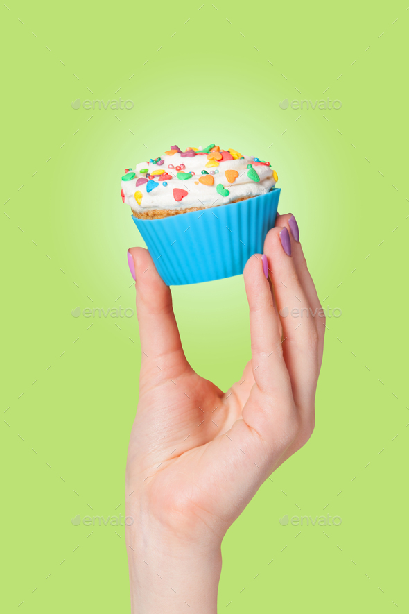Hand holding cupcake on green background Stock Photo by Masson-Simon