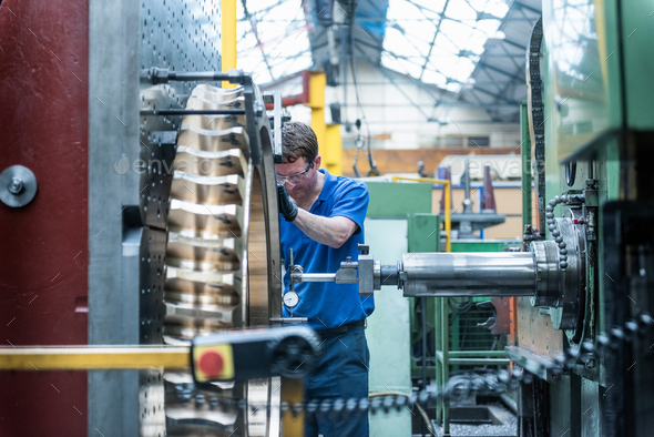 Engineer measuring gear wheel in lathe in engineering factory Stock ...