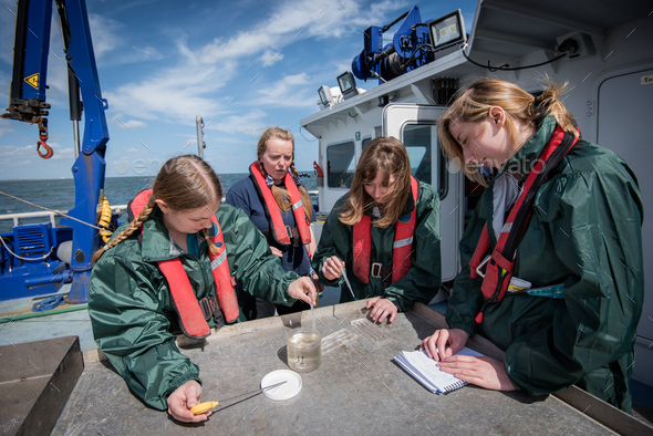 Student marine biologists test sea water sample on research ship Stock ...
