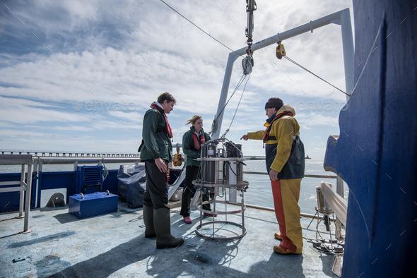 Scientists assembling sea water sampling experiment on research ship ...