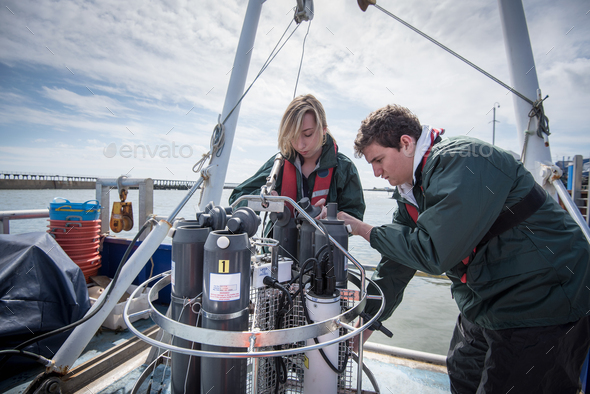 Scientists assembling sea water sampling experiment on research ship ...