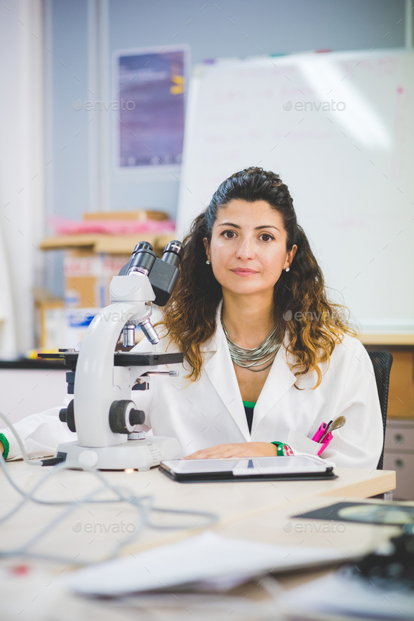 Female scientist using optical microscope Stock Photo by imagesourcecurated