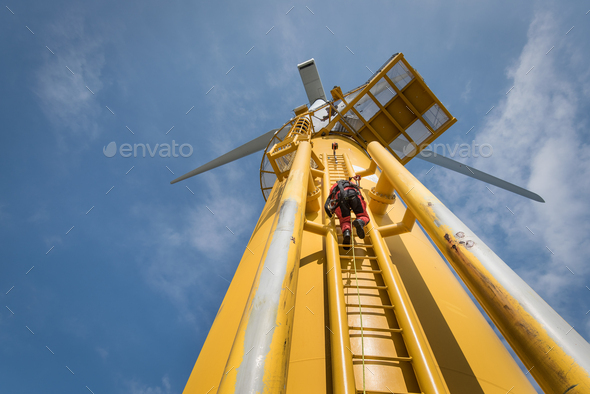 Engineer climbing ladder of wind turbine from boat at offshore windfarm Stock Photo by ...