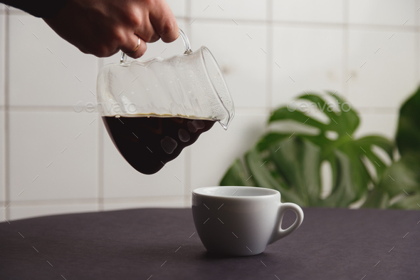man's hand pouring coffee from glass coffee pot into a white cup. Stock ...