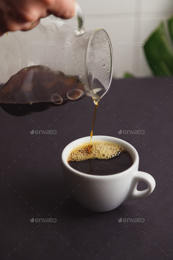 man's hand pouring coffee from glass coffee pot into a white cup Stock ...