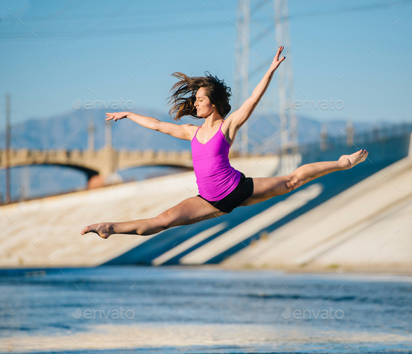 Dancer in mid air, arms raised doing the splits, Los Angeles ...