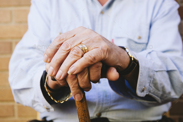 Close-up of old man's hands resting on a cane Stock Photo by westend61