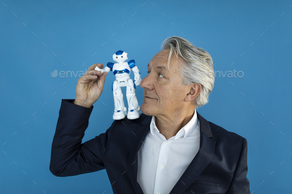 Senior businessman with robot on his shoulder Stock Photo by westend61