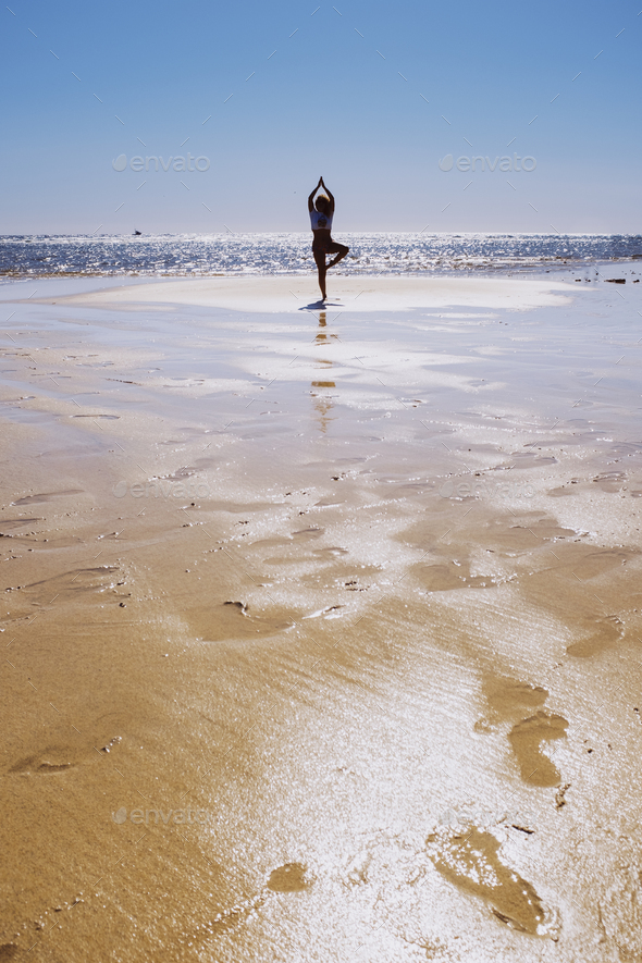 Yoga balanced posture for woman in silhouette standing at the beach ...