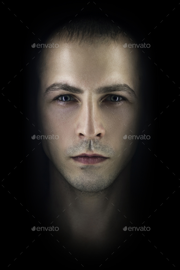 Contrasting male portrait on black background. Light and shadow on the ...