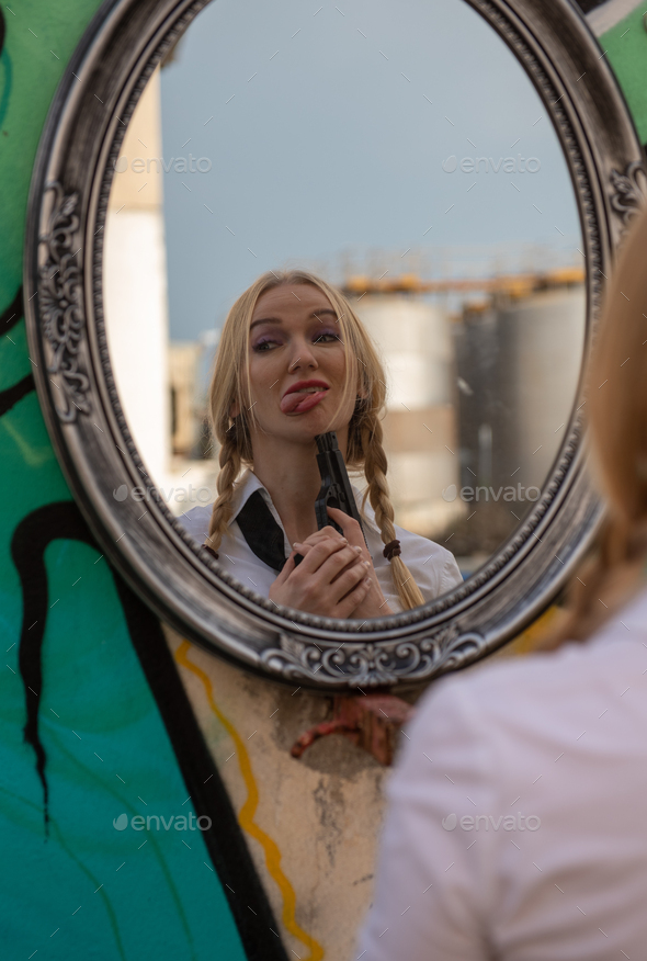 Attractive woman with gun pistol shooting her face. Portrait on the ...