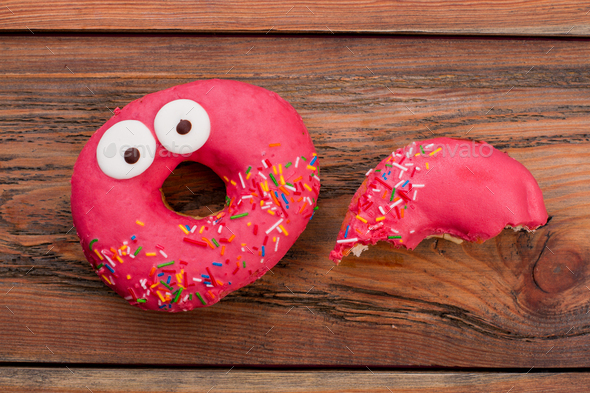 Funny whole donut and piece of donut. Stock Photo by stockfilmstudio