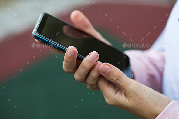 Smartphone in women's hands close-up. Using the phone, fingers on the ...