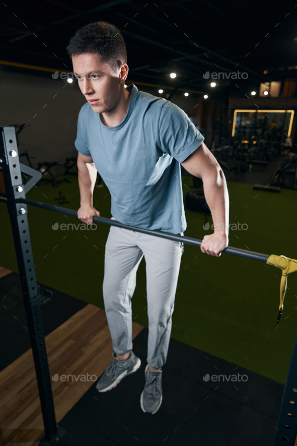 Concentrated male athlete performing advanced strength-training ...