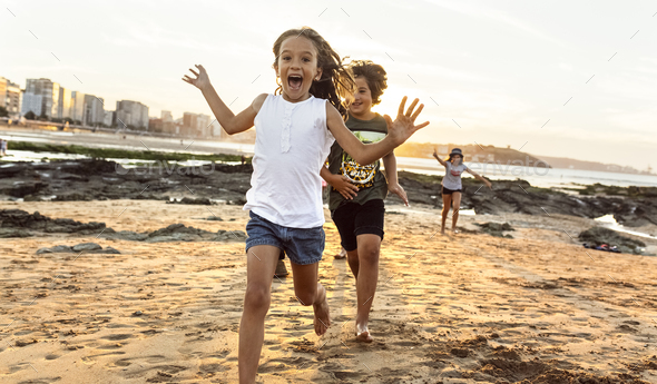 Kids running on the beach at sunset Stock Photo by westend61 | PhotoDune