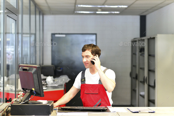 Car mechanic on the phone in service area of a car workshop Stock Photo ...