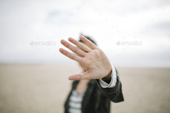 Young woman hiding face behind her outstretched hand Stock Photo by ...