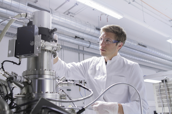 Scientist standing in analytical laboratory with scanning electron ...