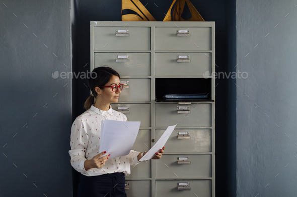 Portrait of office worker, reading documents Stock Photo by westend61