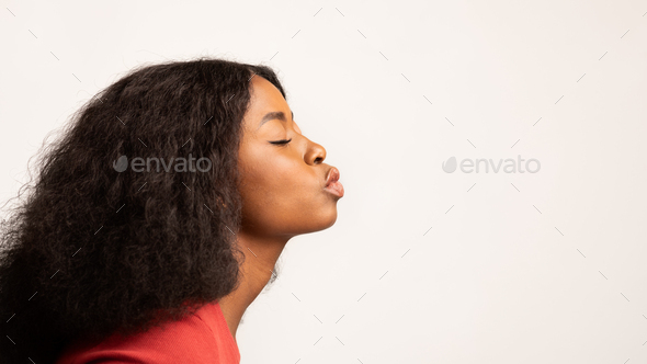 Profile Shot Of Young Black Woman Pouting Lips Over White Studio ...