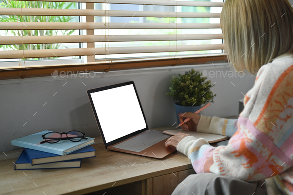 Side view young woman working with laptop computer at home. Stock Photo ...