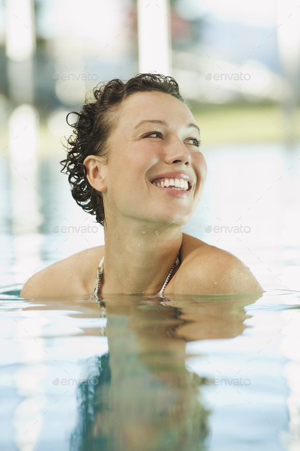 Italy, South Tyrol, Woman in swimming pool of hotel urthaler, smiling ...