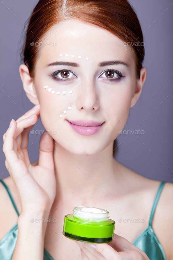 photo of beautiful young woman using her cream on the wonderful grey ...
