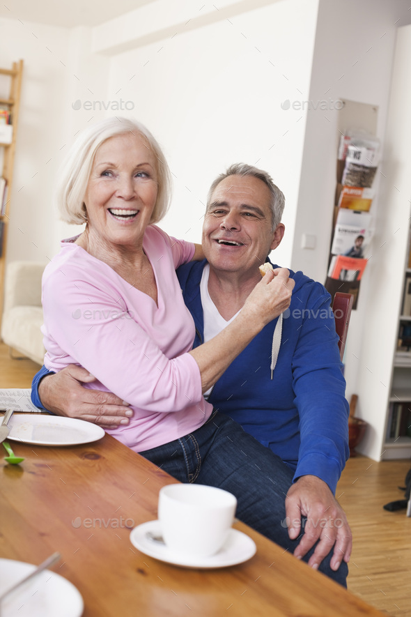 Germany, Leipzig, Senior woman sitting on man's lap, smiling Stock ...