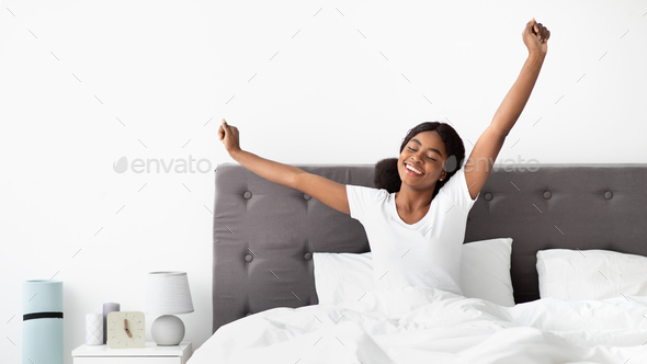 Well-rested black woman enjoying happy morning, stretching in bed Stock ...