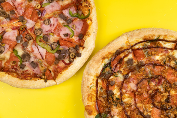 Two different Delicious big pizzas on a yellow background Stock Photo ...