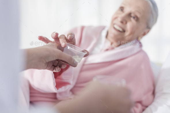 Patient lying in hospital bed receiving medication Stock Photo by westend61