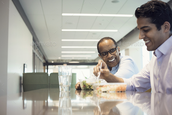 Colleagues in office having lunch together Stock Photo by westend61