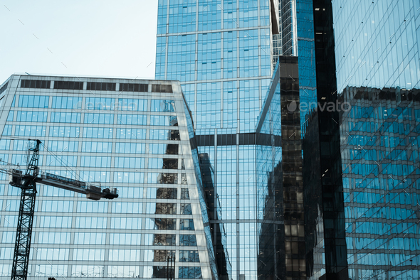 Modern office buildings and crane. Skyscraper construction, business ...